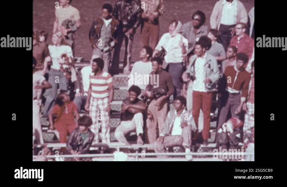 1970s: Needle points to number 23 on scale. Crowd claps and cheers ...