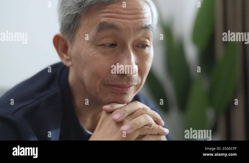Thoughtful sad asian senior grey haired retired man at living room ...