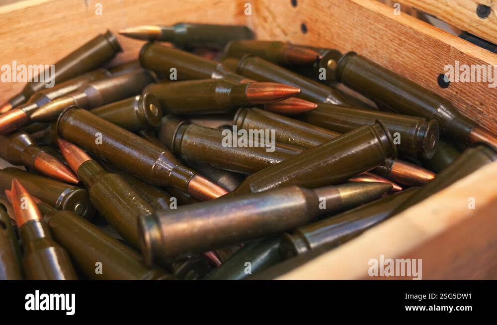 Close-up photo of rifle bullets stored in wooden box. Firearm ...