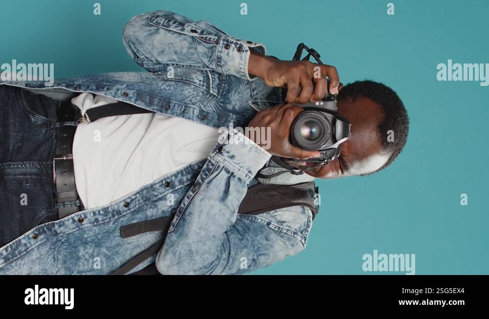 Vertical video: Cheerful photographer holding dslr camera to capture ...