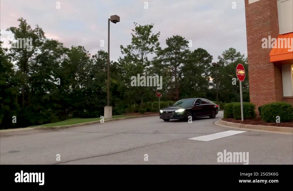 Pan in to BoJangles fast food restaurant car drive thru exiting front ...