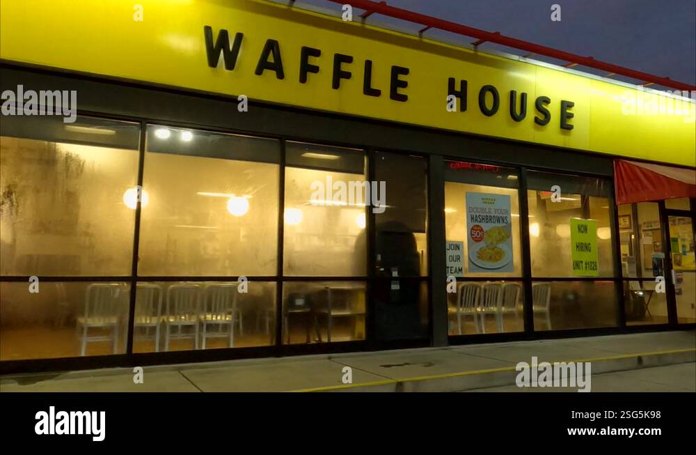 Waffle House restaurant exterior close up pan by people inside early ...