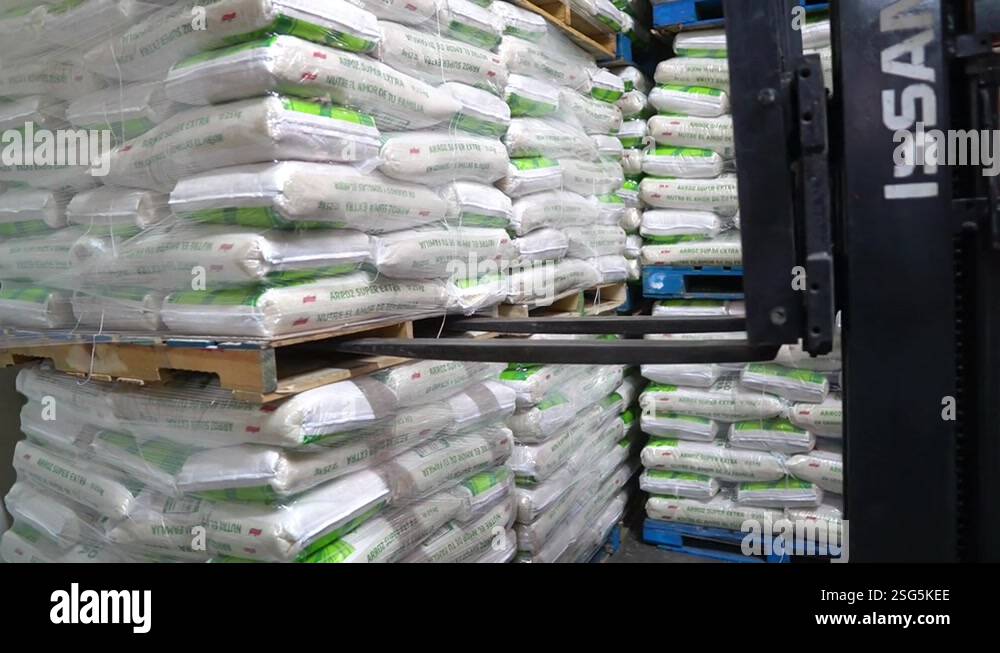 Warehouse worker driver in loading by forklift stack pallet loader ...