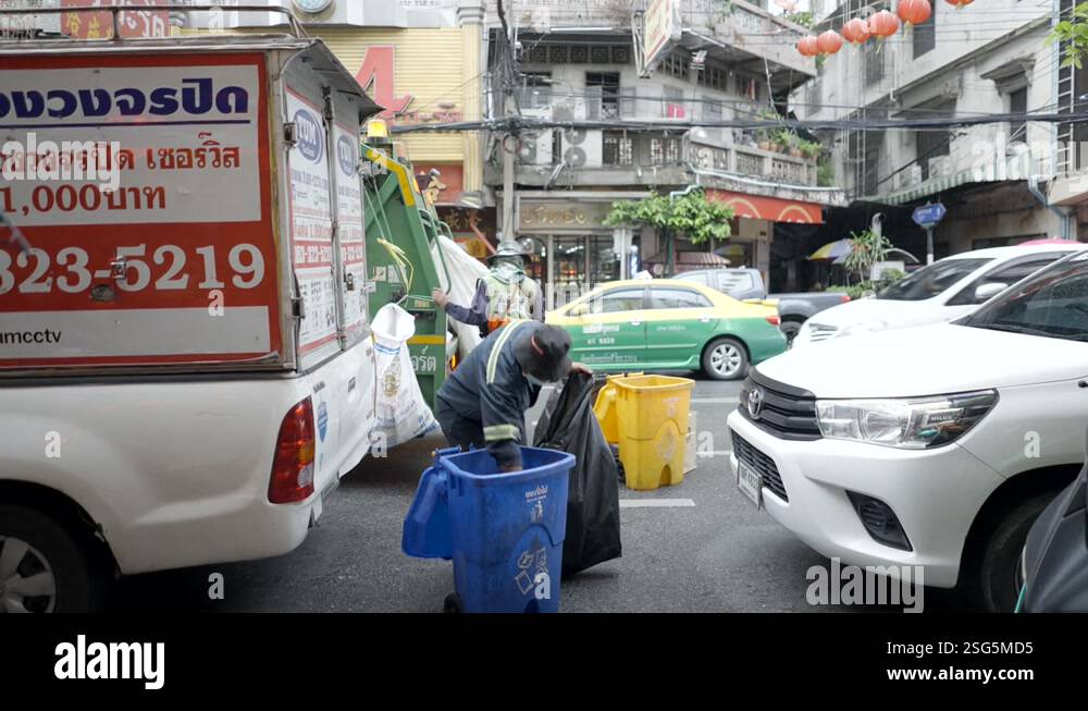 Waste Collector Collecting The Garbage On Trash Bin In The Street Of ...