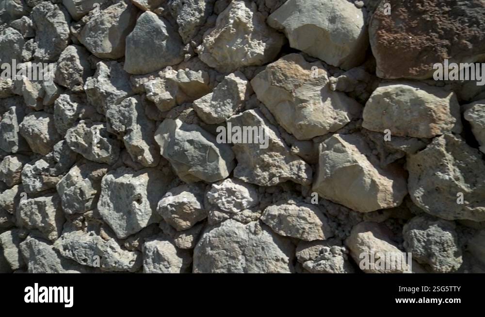 Right panel, rough unworked stone wall with cement visible between the ...