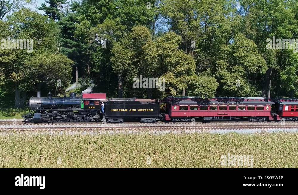 A Drone Side View of an Antique Steam Passenger Train in Slow Motion ...