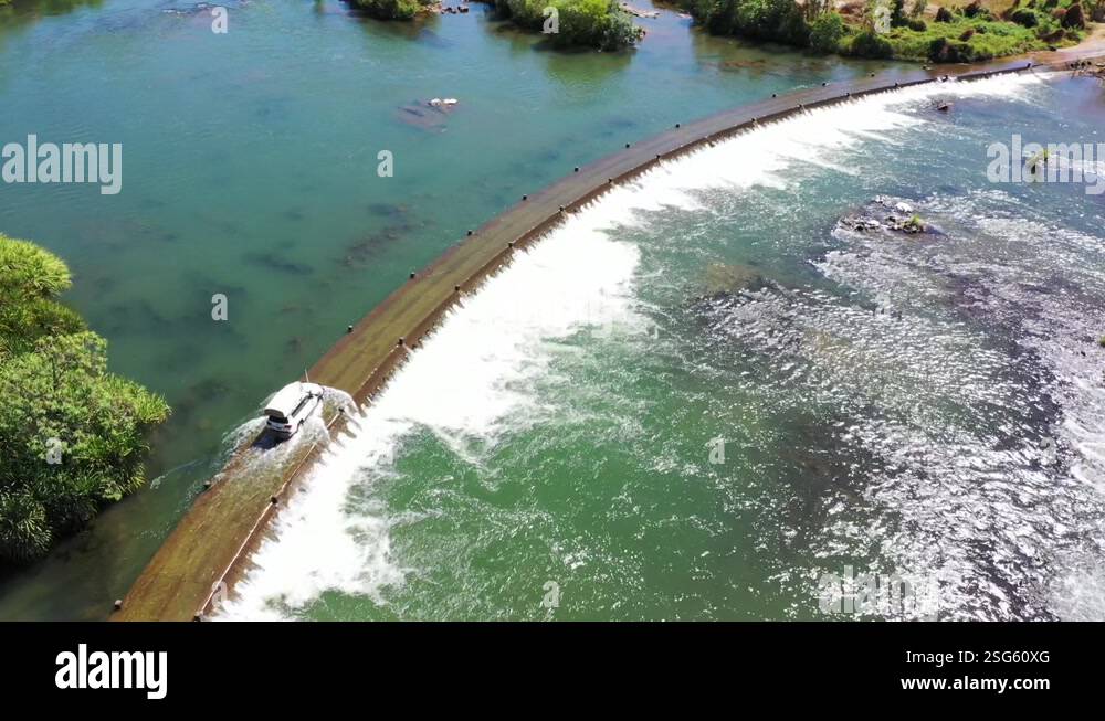 Car driving on Ivanhoe Crossing a concrete causeway on Ord River near ...