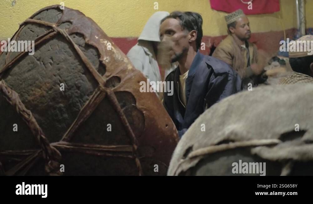 Man beating drum during a sufi ceremony in Ummi Tahir Nabigar, Harar ...