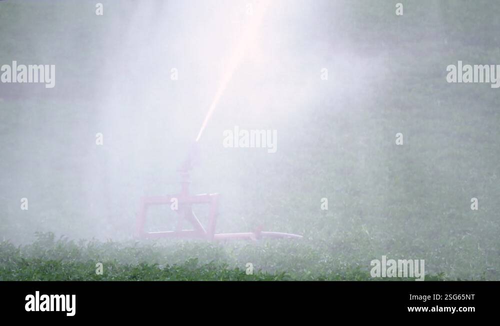 Water Splash As Irigation Sprinklers water a Dry Field During a Drought ...