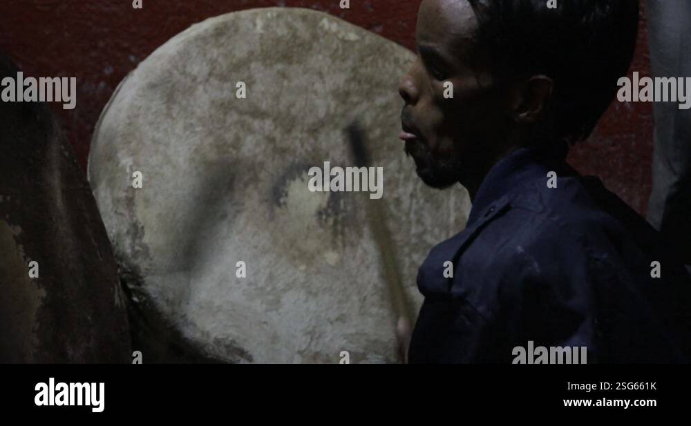 Man beating drum during a sufi ceremony in Ummi Tahir Nabigar, Harar ...