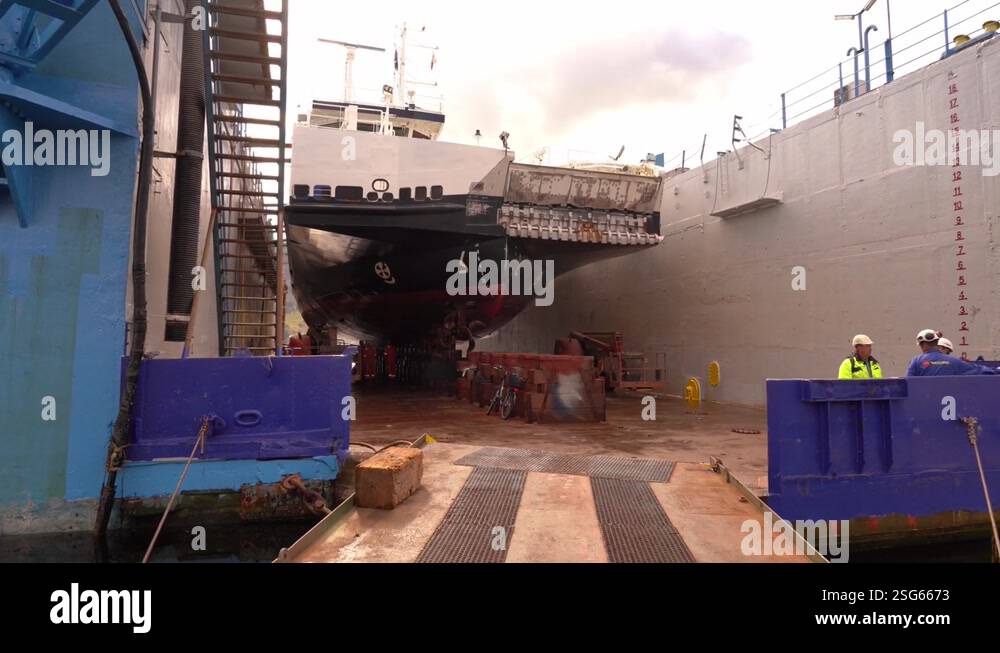 Walking inside drydock with ferryboat inside for cleaning of ships hull ...