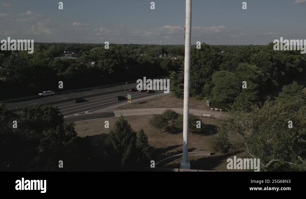 An aerial view of an American flag blowing in the wind in a park on a ...