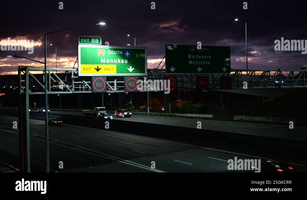 Moderate evening traffic on highway 20 underneath large signs and a ...