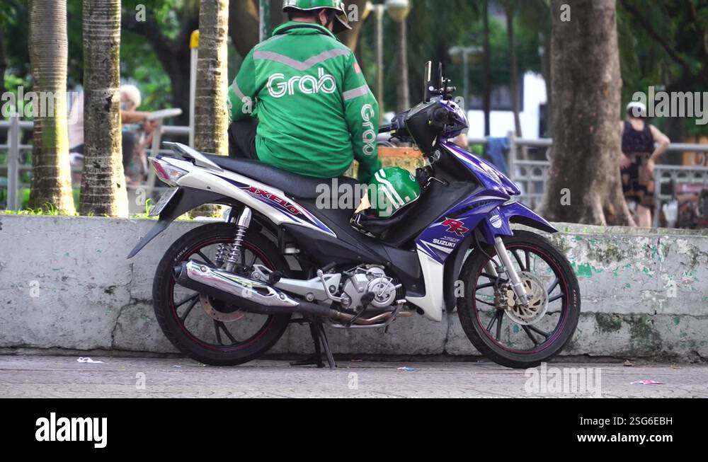 Grab Rider Sitting On His Motorbikes Parked In The Street Of Ho Chi ...