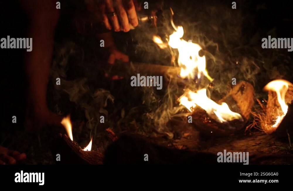 Fire up wooden torch from burning flames on the ground in the jungle on ...