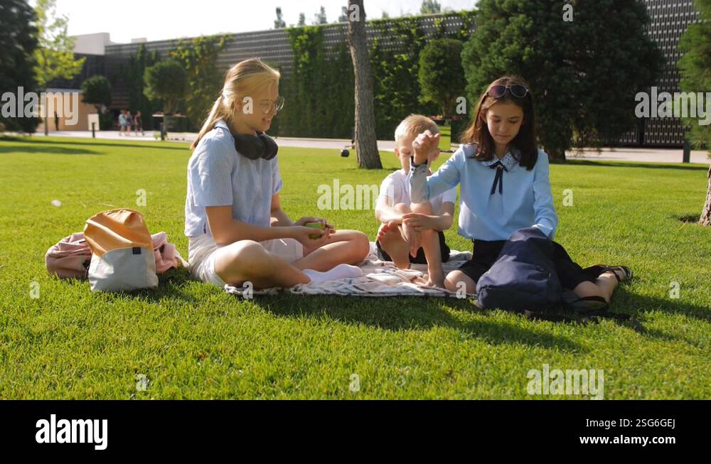 A preteen girl treats her friends with green apples during school break ...
