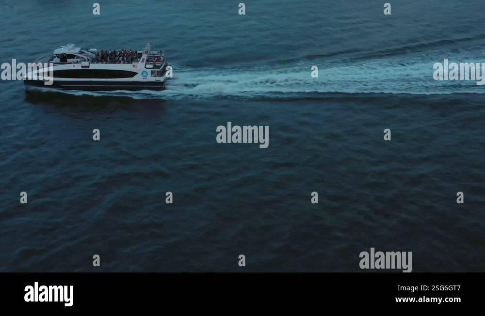Aerial pan tilts up from ferry boat to the lower Manhattan New York ...