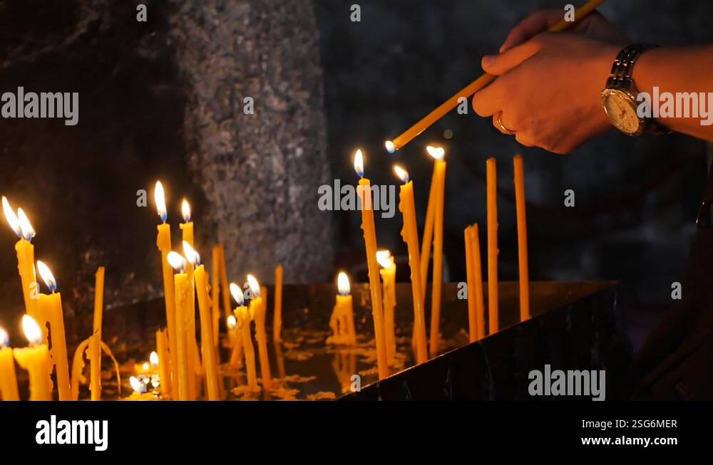 men's hands in a gold wristwatch and a gold ring on their finger light ...