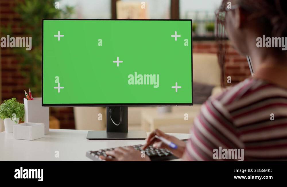 Freelancer woman working remotely with greenscreen on computer Stock ...
