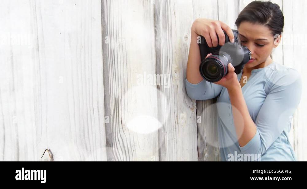 White spots floating against caucasian female photographer checking ...