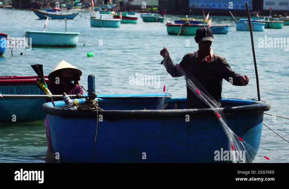 Fisherman sorting net from one boat to another in Vietnam, Mui Ne Stock ...