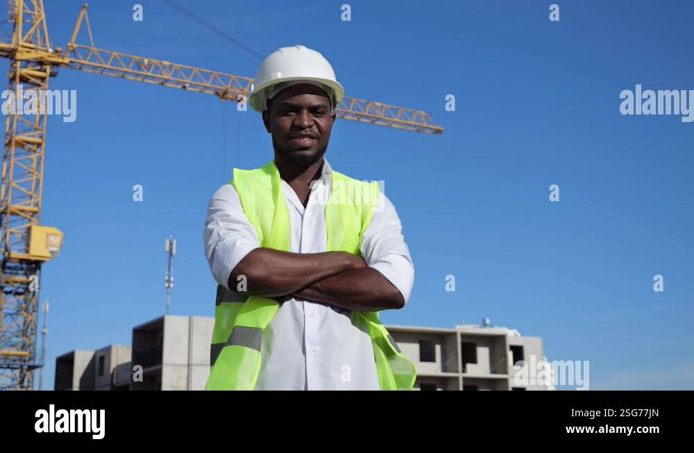 African American builder looks with happy expression by crane Stock ...