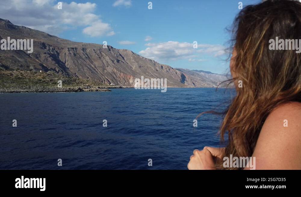 Woman in her thoughts watching the horizon roll by from the deck of a ...