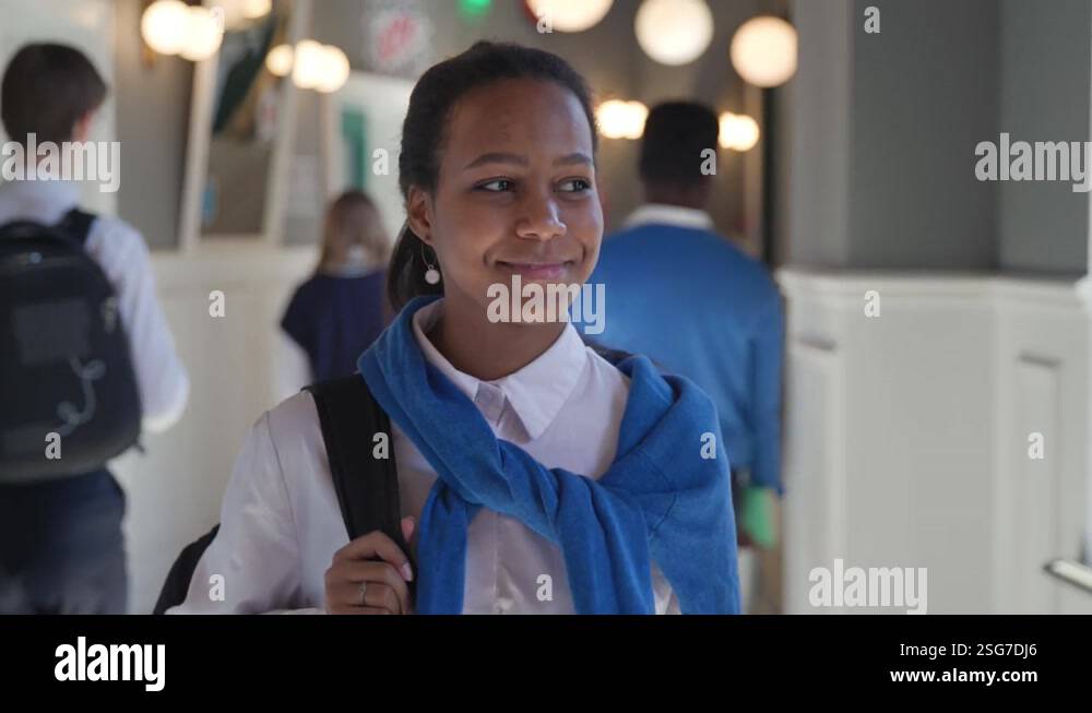 Smiling African-American teenage student walk in school campus Stock ...