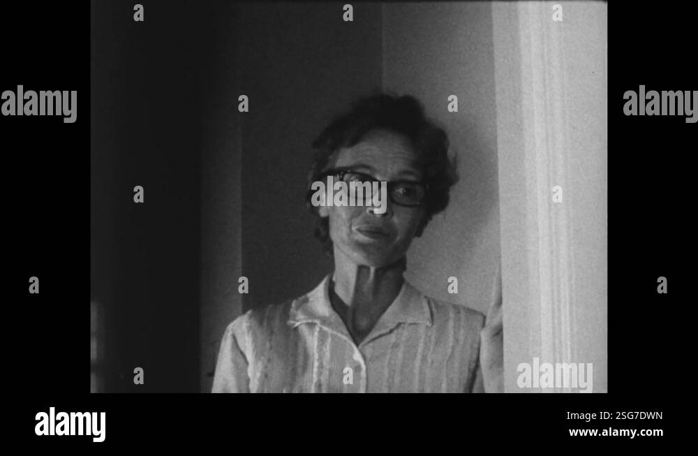 1960s: Woman leans on wall and speaks through doorway. Teenage boy talks and Stock Video Footage ...
