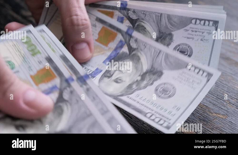 Unrecognizable man calculating cash dollars indoors. Paying in cash ...