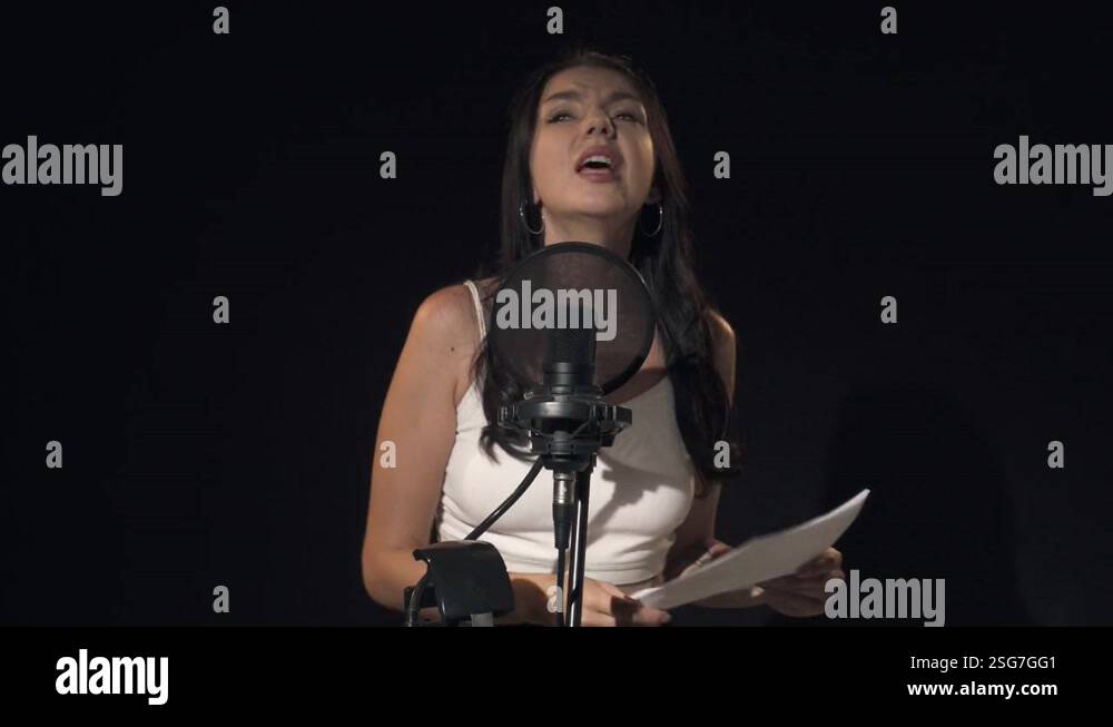 Portrait of an Emotionally Female Talented Singer in headphones singing ...