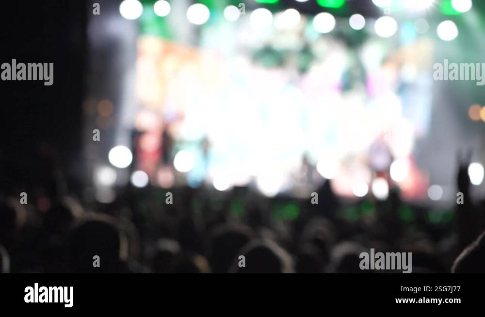 Illuminated and blurry dancing crowd at a concert. Silhouette of people ...