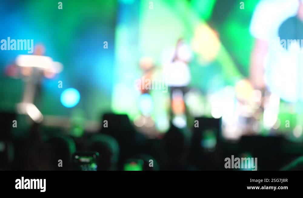 Illuminated and blurry dancing crowd at a concert. Silhouette of people ...