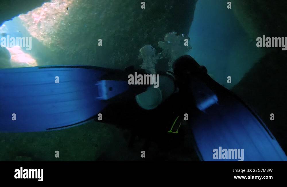 Scuba diver preparing to go into underwater cave - from behind Stock ...