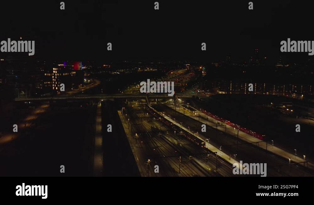 Forwards fly above transport infrastructure at night. Commuter train ...