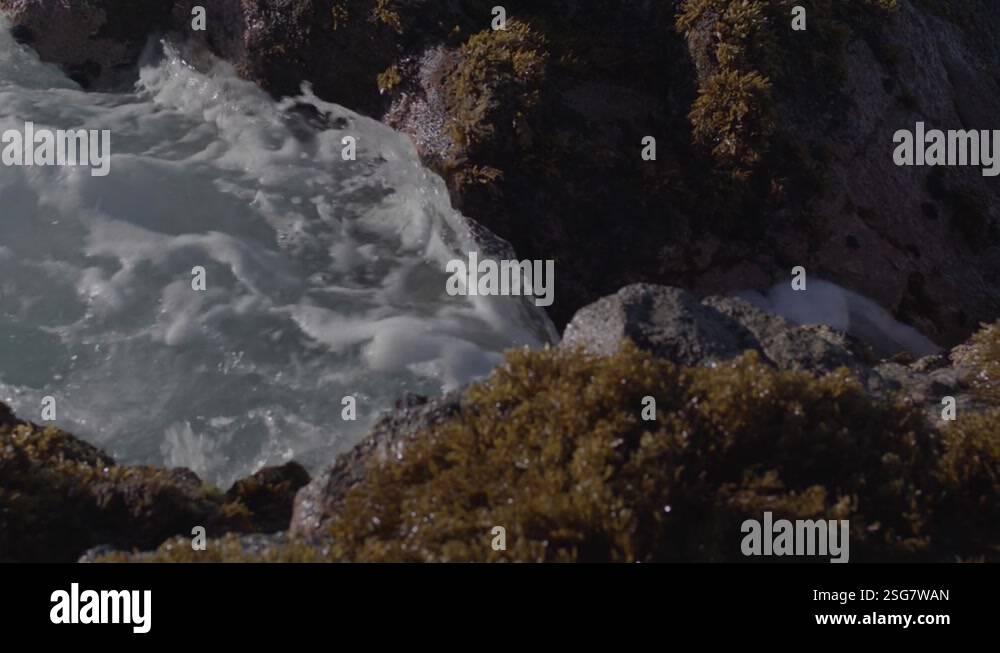 Clear ocean water incoming tide filling up a tide pool during the ...