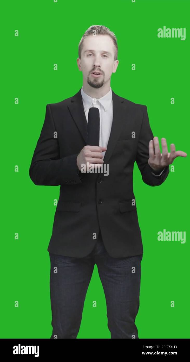 Male reporter in business wear holding microphone show back on green ...