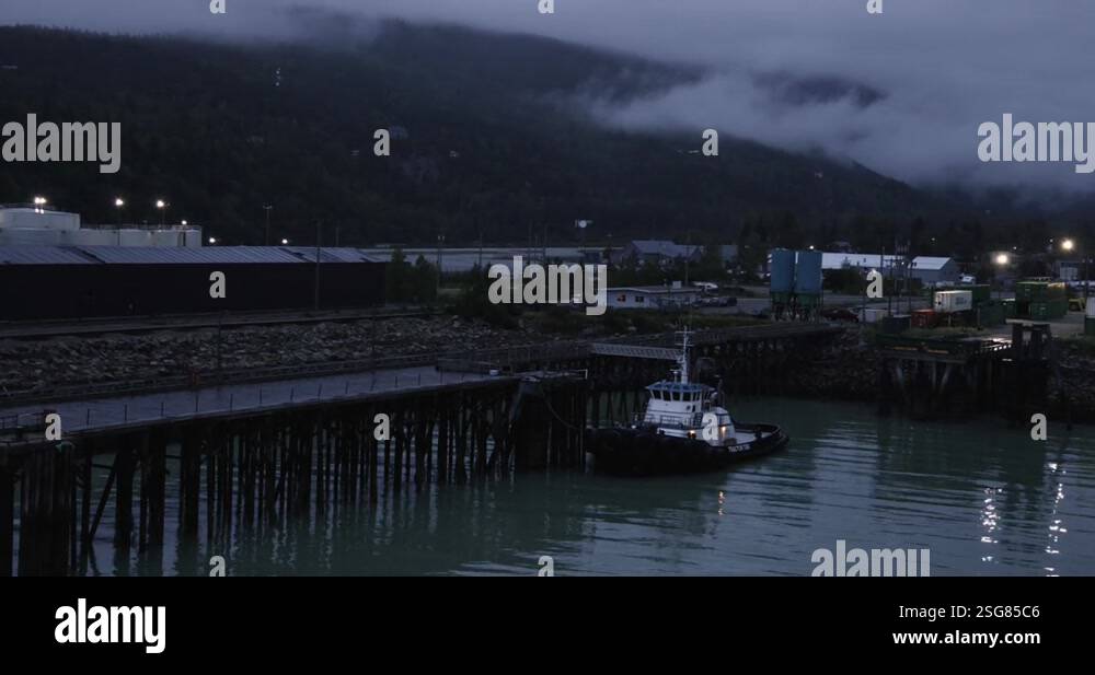 Night Skagway harbor-Lights on moored tug boat reflect in water Stock ...