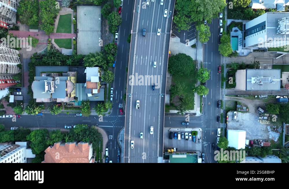 Top down tracking aerial view of busy road, with lots of cars, trees ...