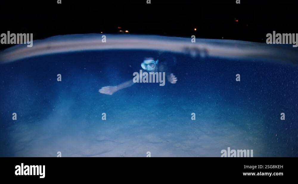 Night underwater swim. Young woman swims underwater at night Stock ...