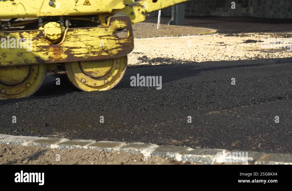 Working with asphalt roller for compacting and smoothing surface at ...
