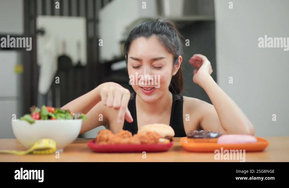 Beautiful female stop eat fried chicken junk food and make healthy food ...