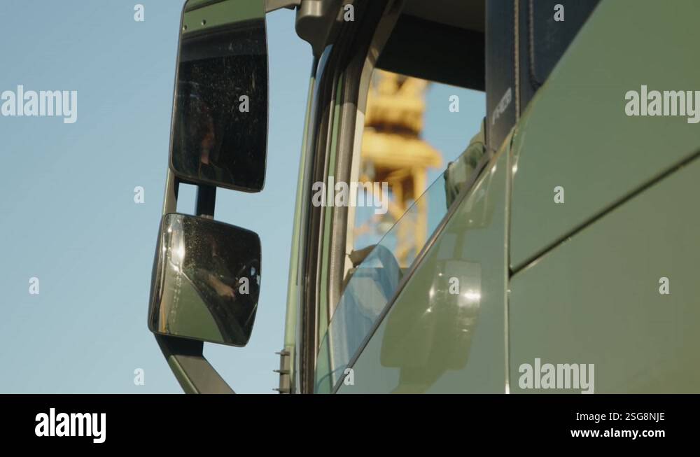 handheld shot side mirror on a truck slowly driving on shipyard crane ...