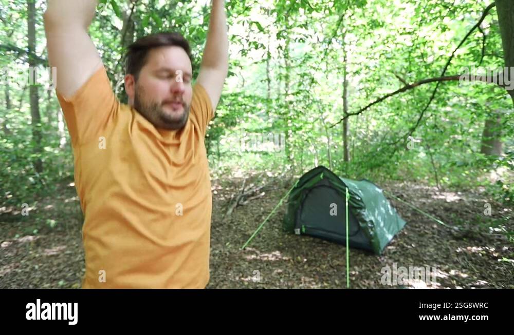 Man doing morning routine jumping jacks after waking up in forest ...