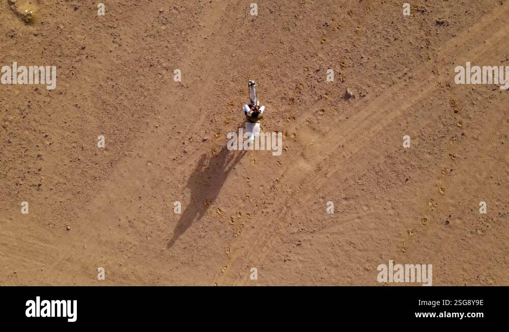 A following drone shot from the top of a man riding a white horse Stock ...