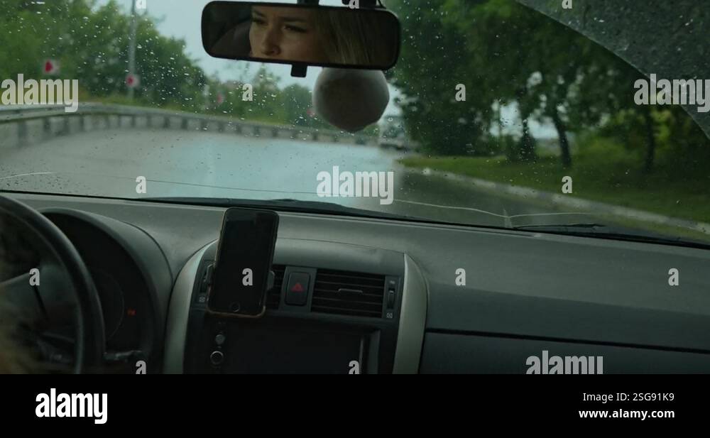 The girl drives a car, rear view, the car drives along sharp turns ...