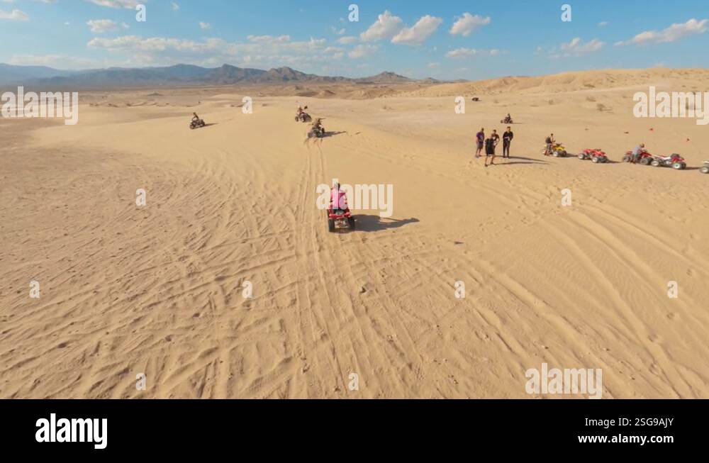 FPV aerial drone shot of an ongoing ATV race through the desert and ...