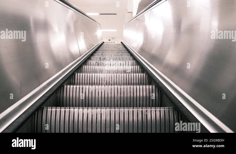 Static footage of escalators stairs and man at the top of the escalator ...