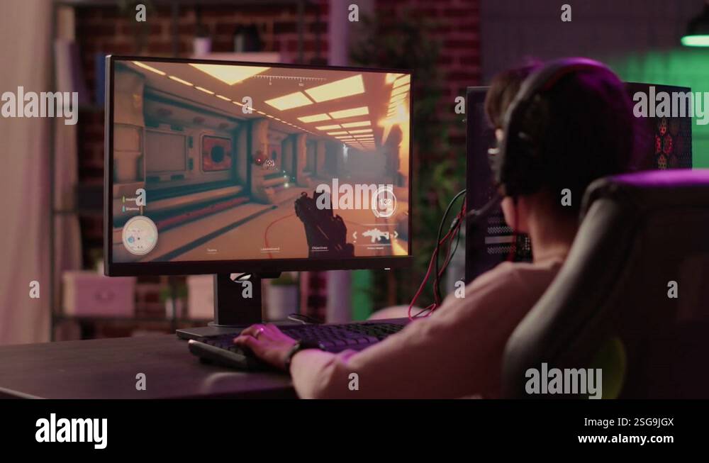 Over shoulder view of gamer girl using pc gaming setup relaxing playing ...