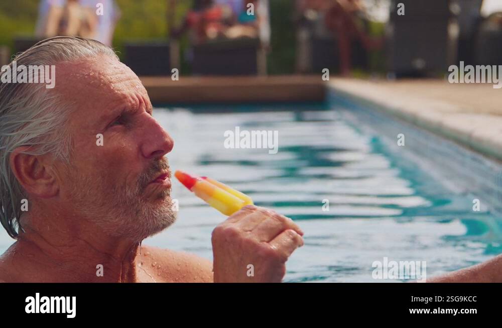 Mother And Son Splashing As He Eats Ice Lolly At Edge Of Swimming Pool ...